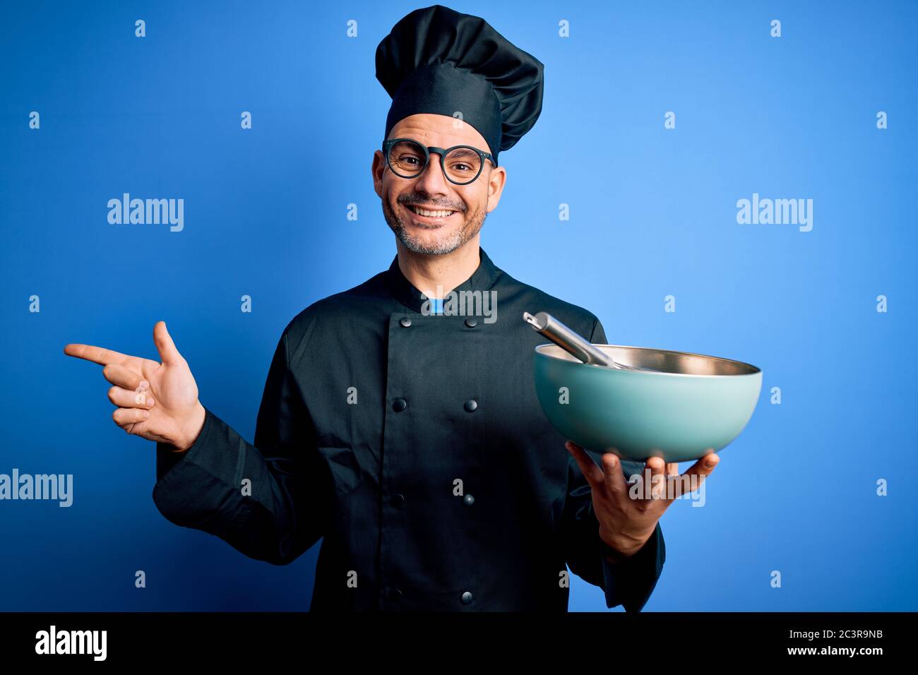 Young handsome chef man wearing cooker uniform and hat mixing using ...