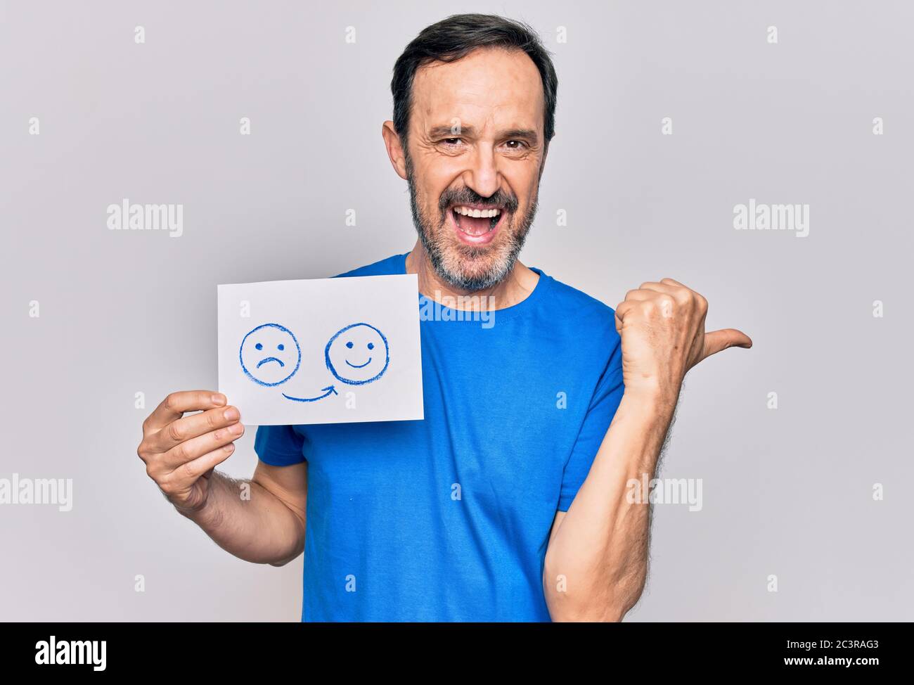 Middle age handsome man holding paper with sad and happy face emoticons ...