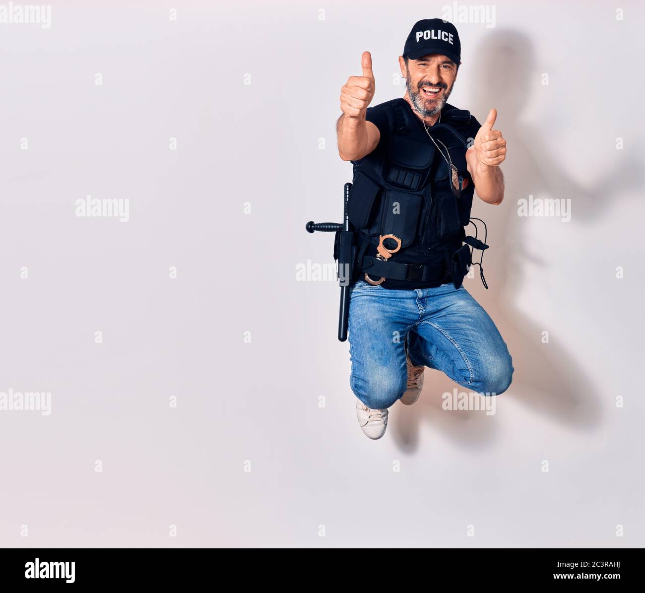 Middle age handsome man wearing police unifrom smiling happy. Jumping ...