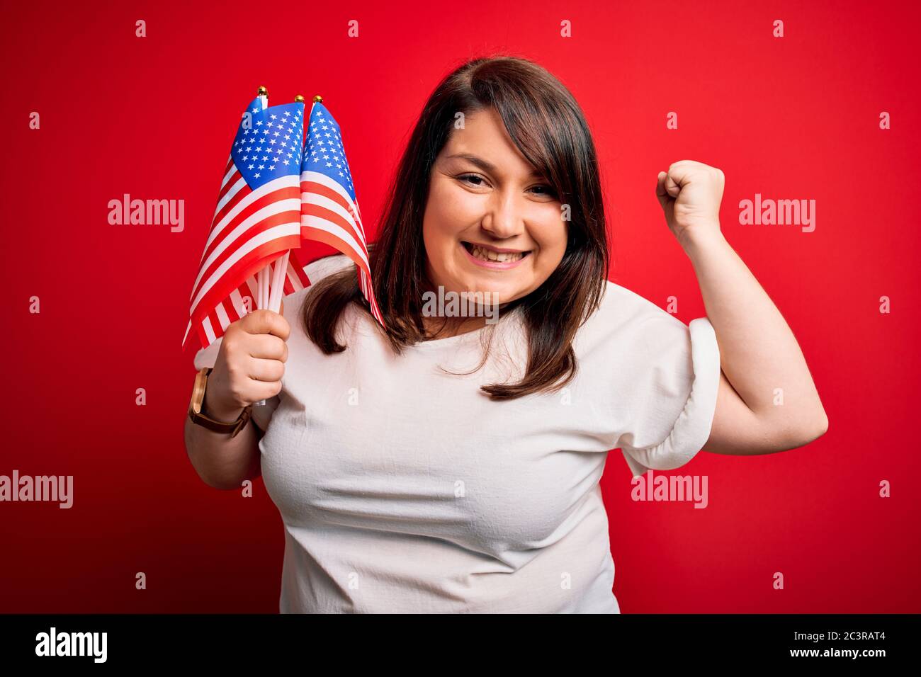 Beautiful plus size woman holding united states of america flag over ...