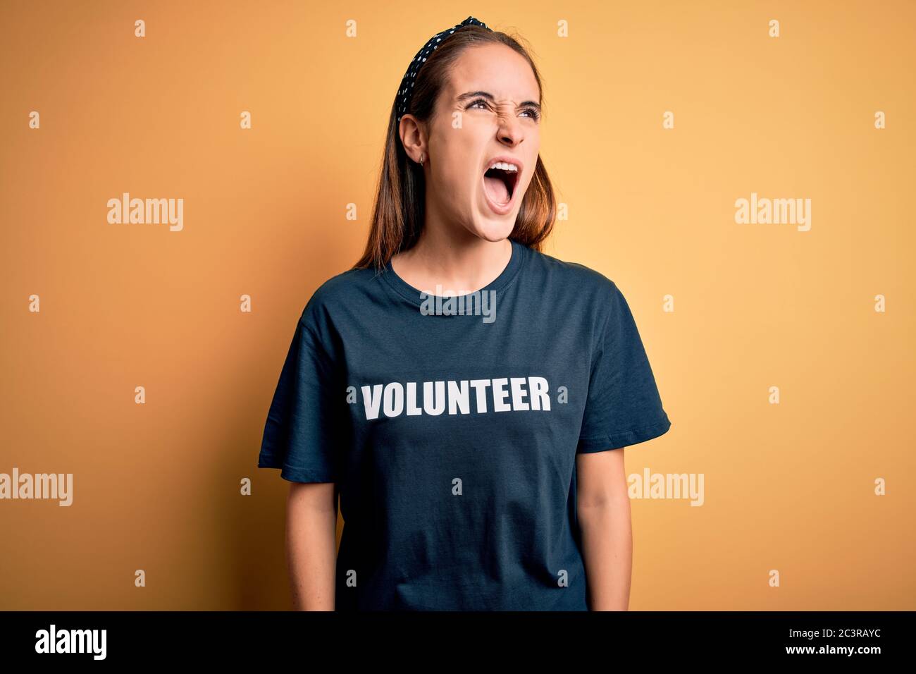 Young beautiful woman wearing volunteer t-shirt doing volunteering over ...
