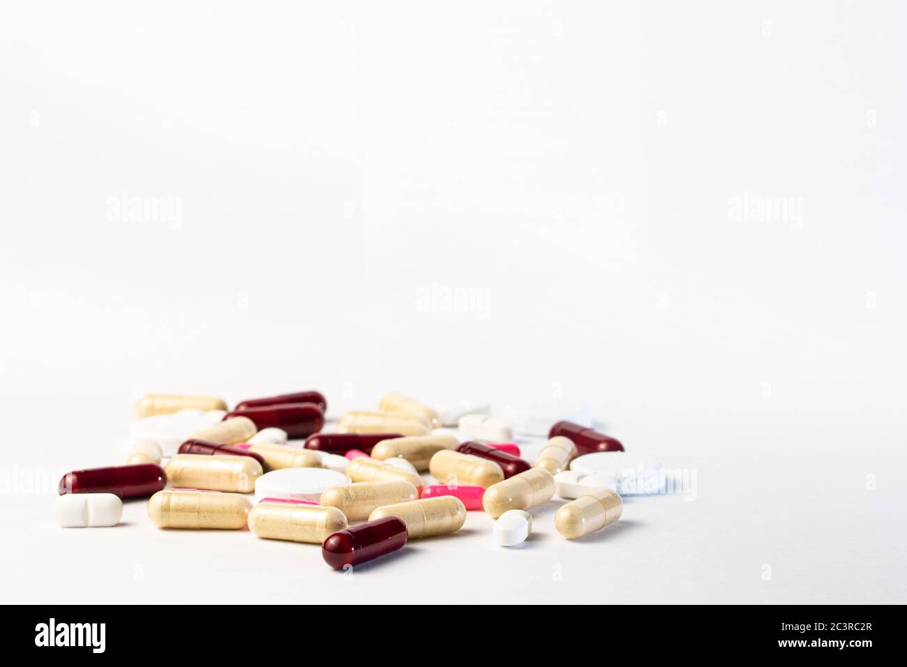 Pile of scattered capsules on a white background Stock Photo - Alamy