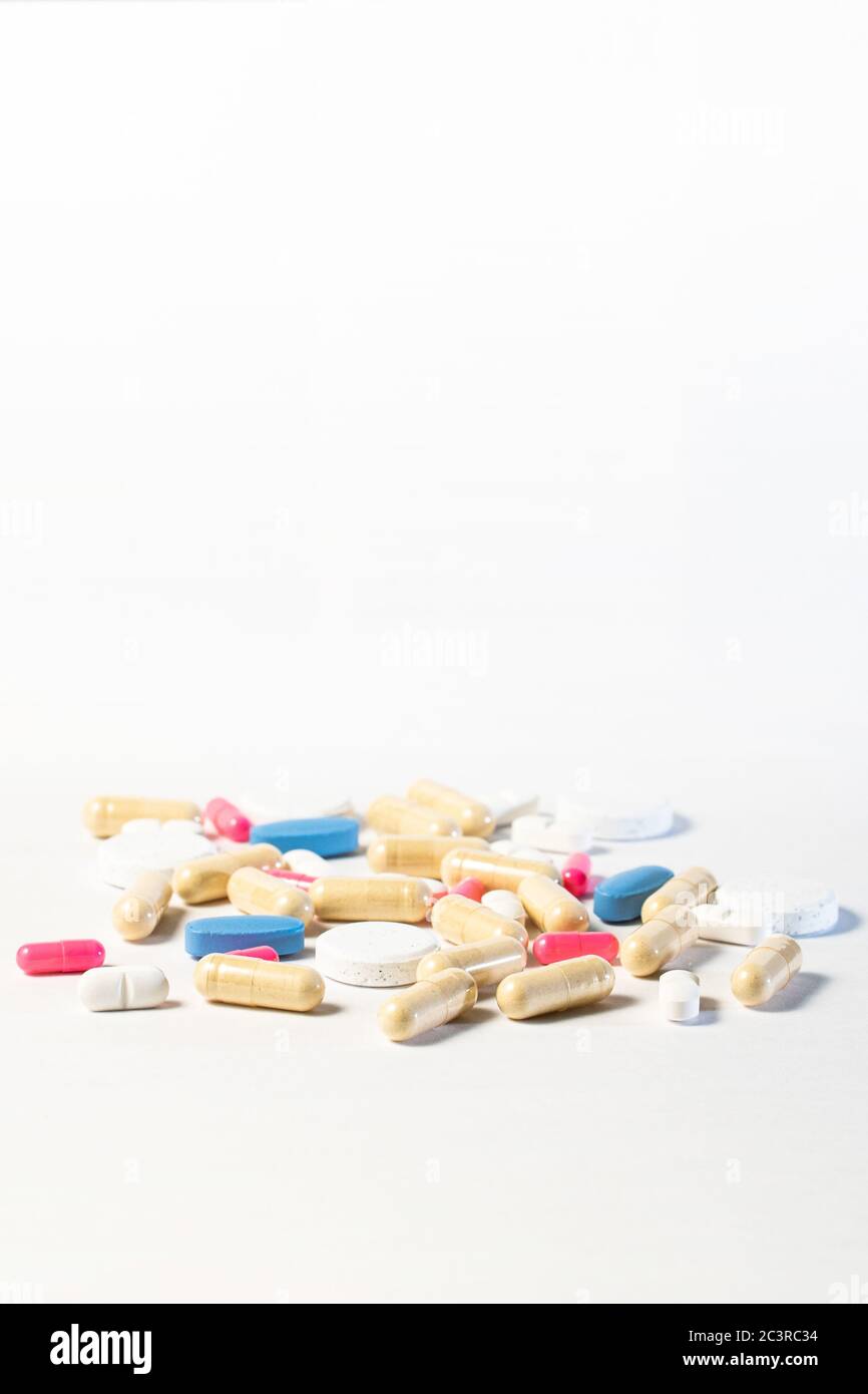 Pile of scattered capsules on a white background Stock Photo - Alamy