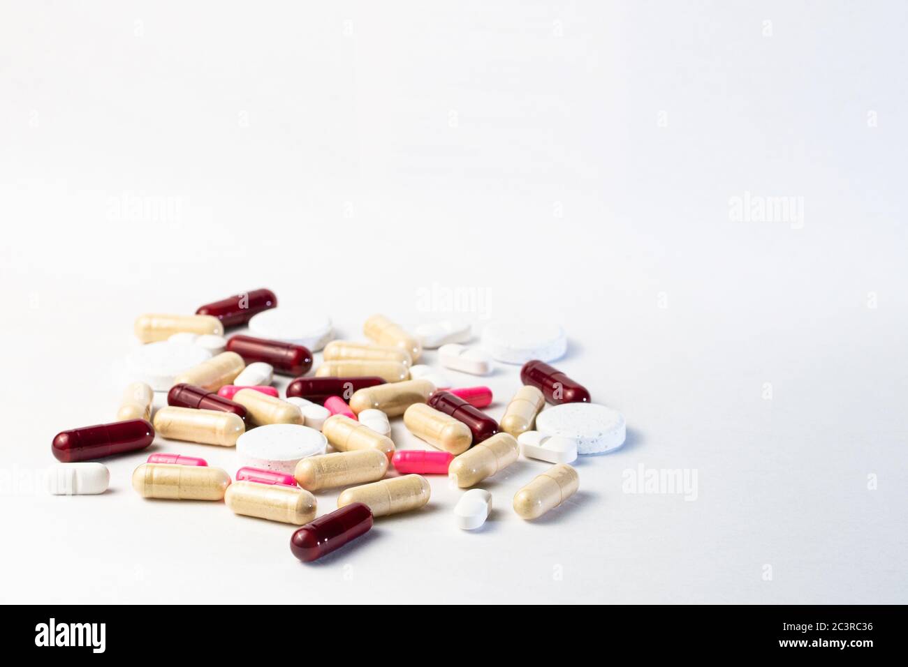 Pile of scattered capsules on a white background Stock Photo - Alamy
