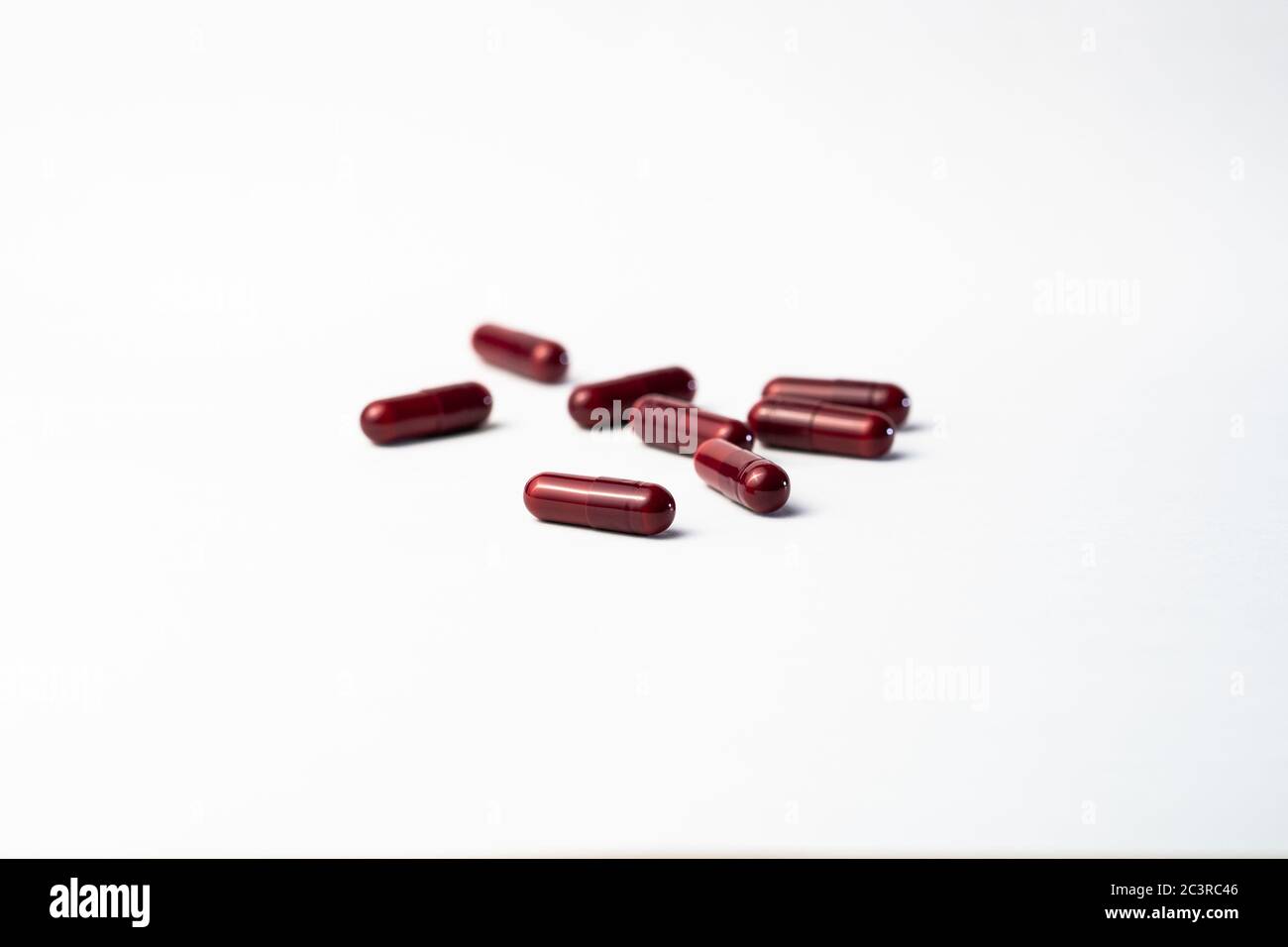 Pile of scattered capsules on a white background Stock Photo - Alamy