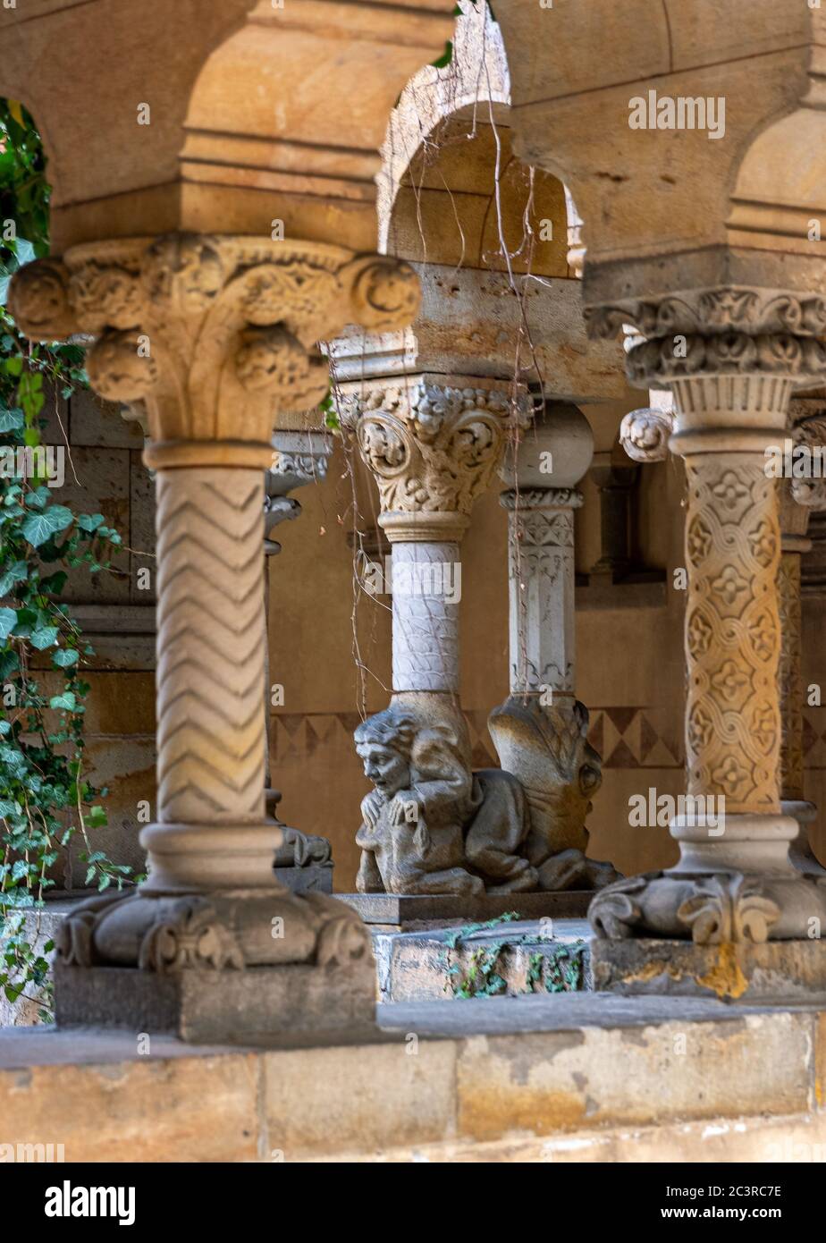 Vertical shot of columns with sculptures in unique architectural design ...
