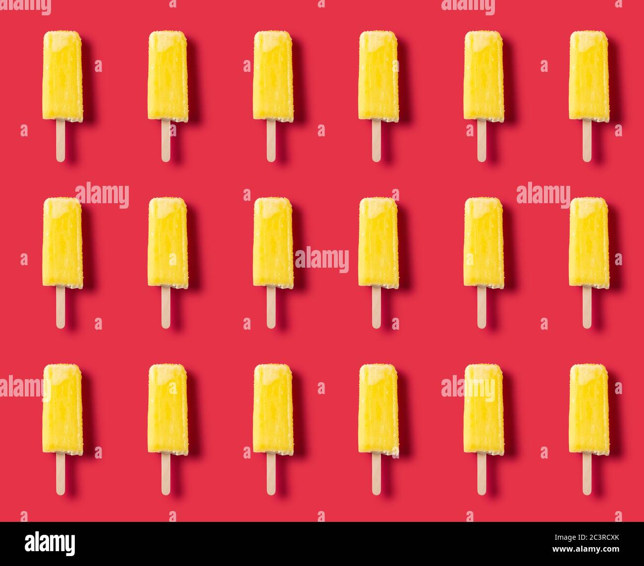 yellow popsicle on a rose red background Stock Photo - Alamy