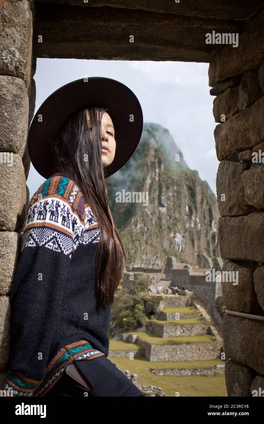 Girl posing at the lost old Inca city Machu Picchu in the Andes ...