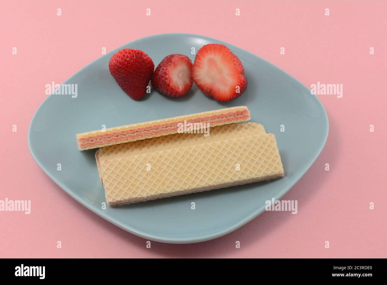 Strawberry sugar wafer cookies and fresh raw strawberries on blue snack ...