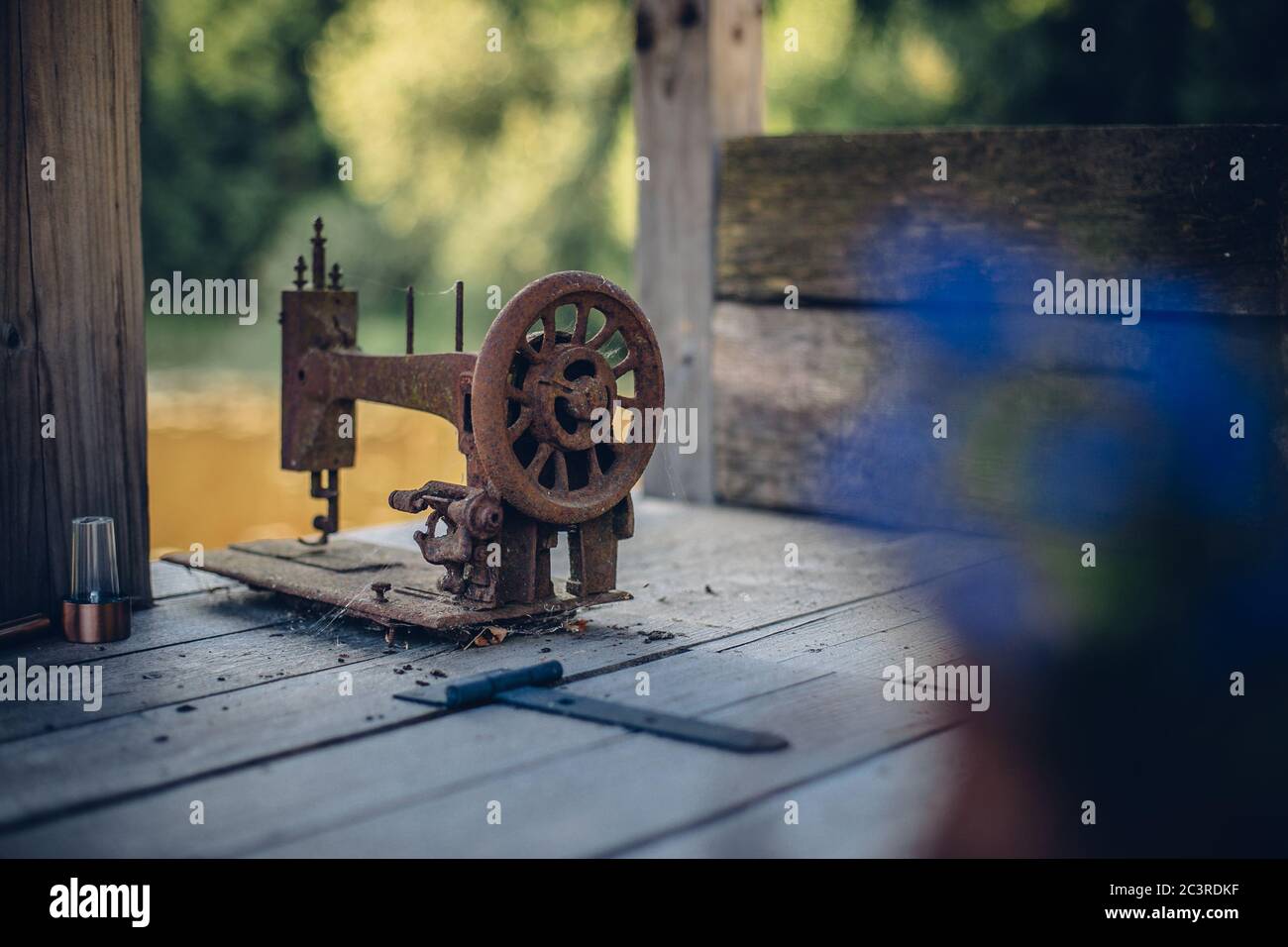 Selective focus of a vintage rusty sewing machine on a wooden board ...