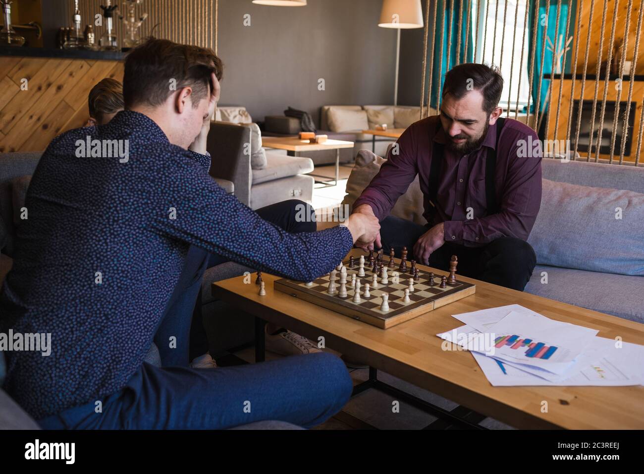 Men play chess in a stylish loft cafe with a modern design Stock Photo ...