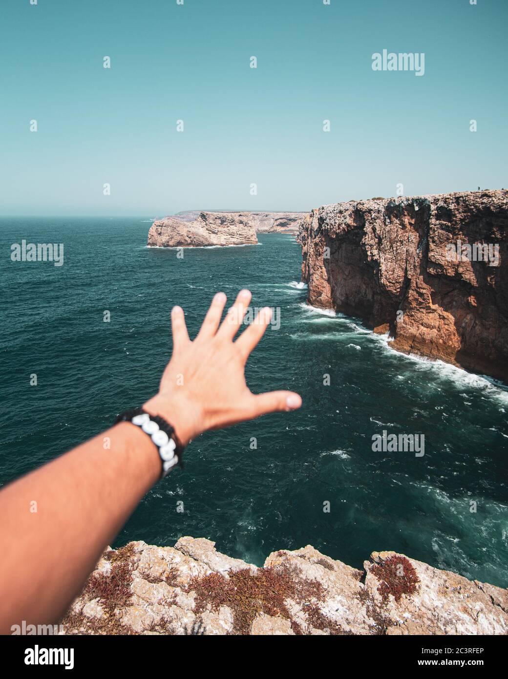 Hand of a man reaching towards the cliffs and the sea Stock Photo - Alamy