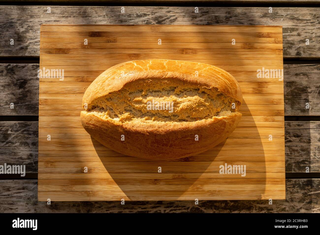 Horizontal shot of sourdough bread on a light wooden cutting board on a ...