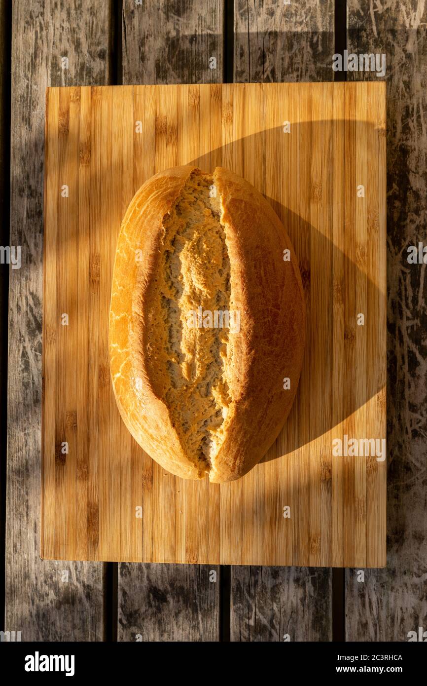 Vertical shot of sourdough bread on a light wooden cutting board on a ...