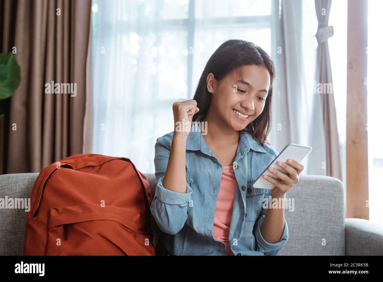 happy excited young girl win the game on smartphone Stock Photo - Alamy