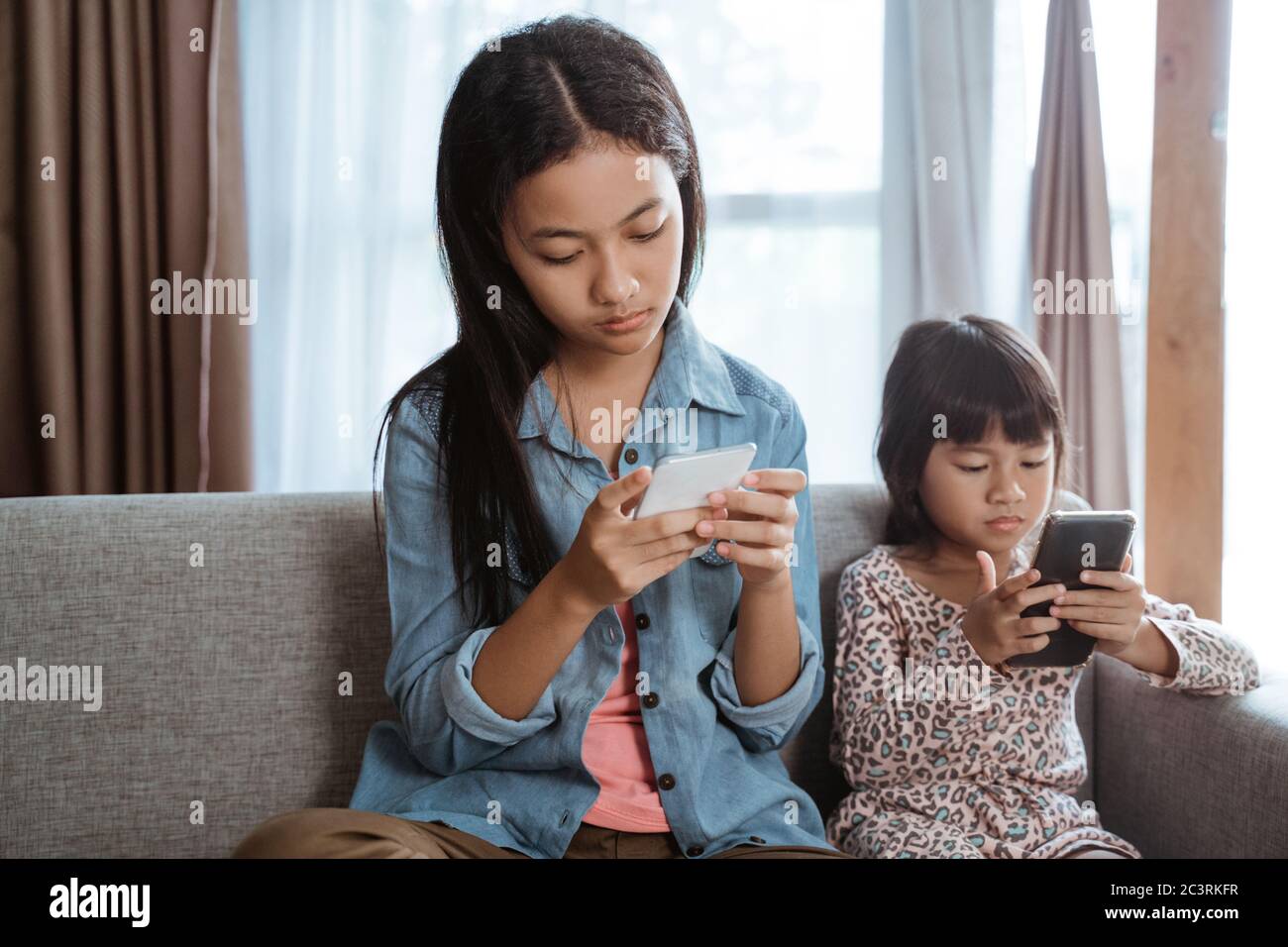 two sibling using mobile phone. smartphone addiction on kid Stock Photo ...