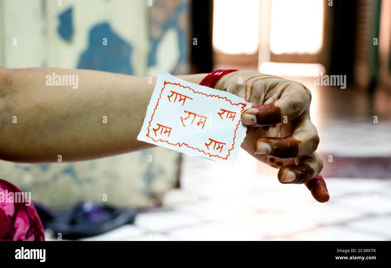 A lady holding a piece of paper with name of lord ram written on it on ...