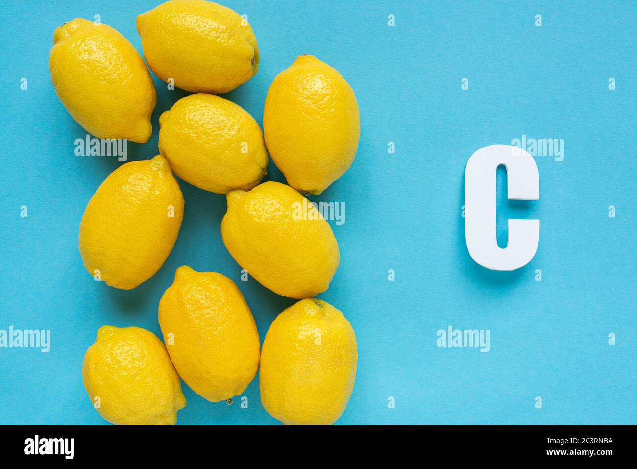 top view of ripe yellow lemons and letter C on blue background Stock ...