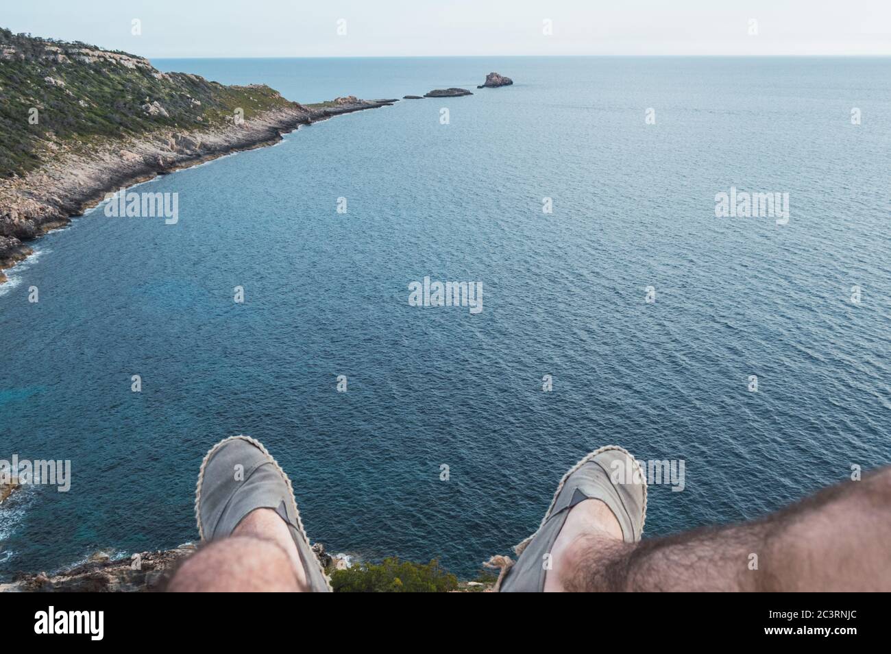 Young male put her feet on the rocky slope of the mountain Stock Photo ...