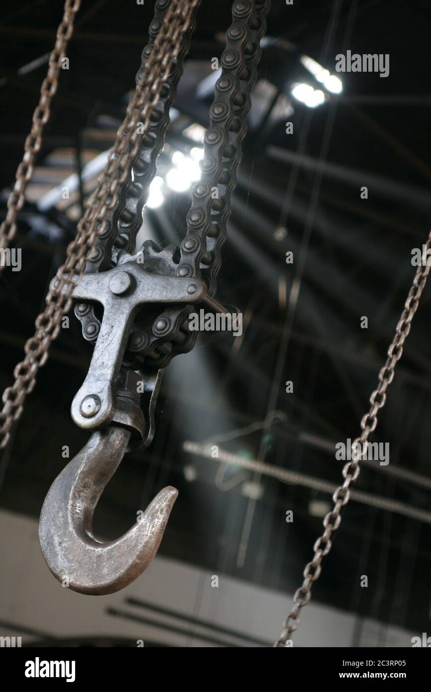 Vertical shot of a hook and chains captured inside an industrial ...