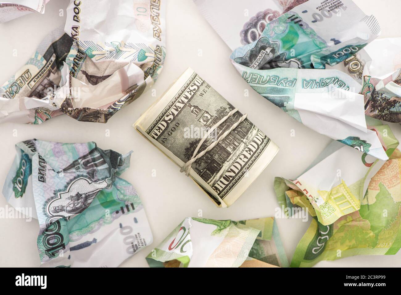 top view of cash roll with dollars near crumpled ruble banknotes ...