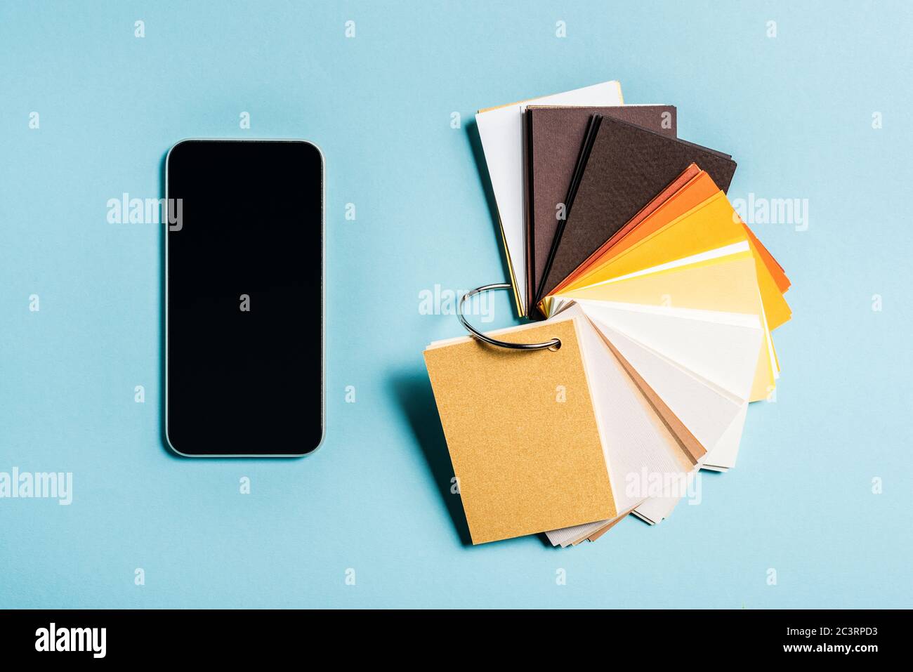 Top view of colorful samples and smartphone with blank screen on blue ...