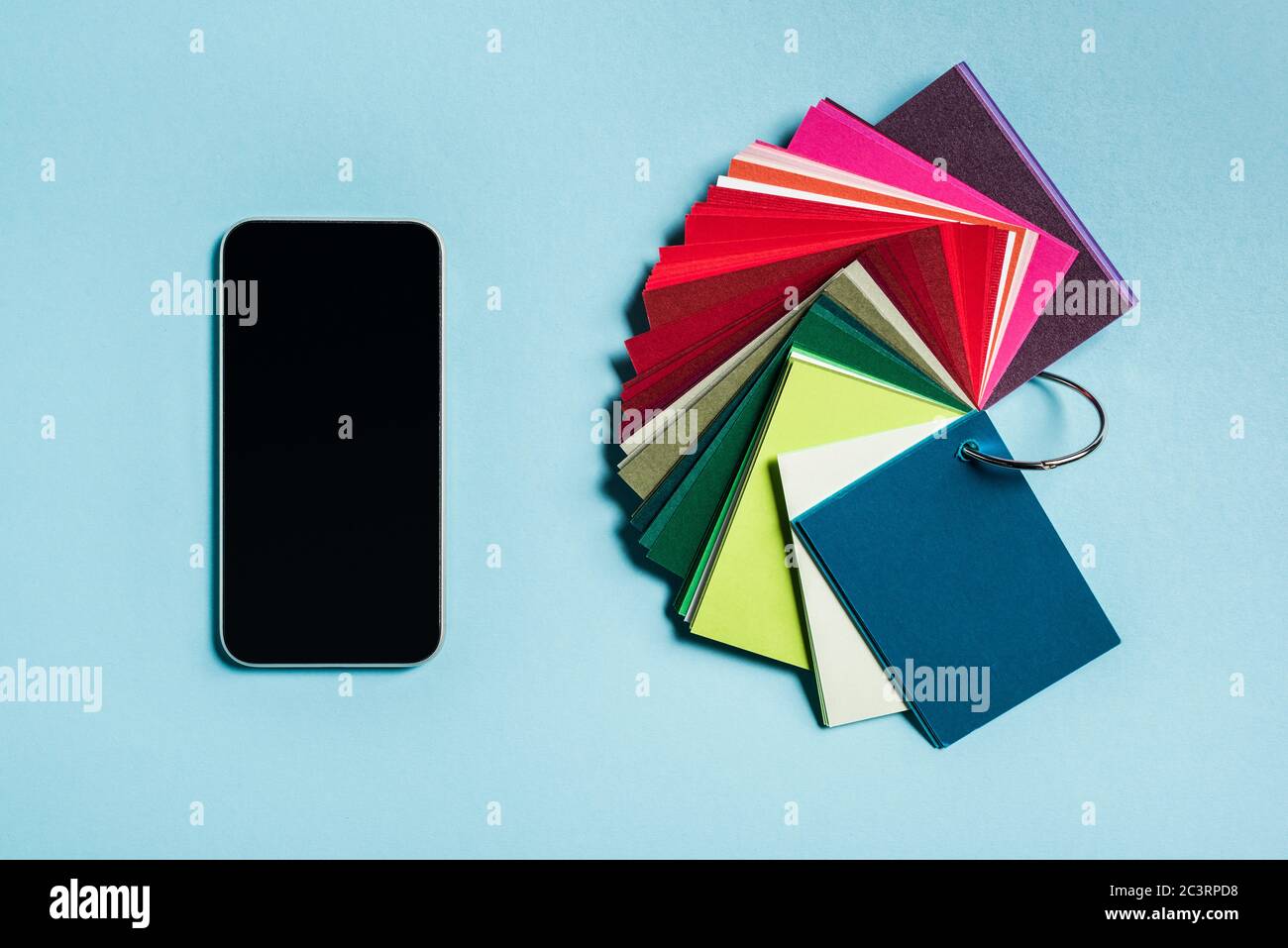 Top view of smartphone and color samples on blue surface Stock Photo ...