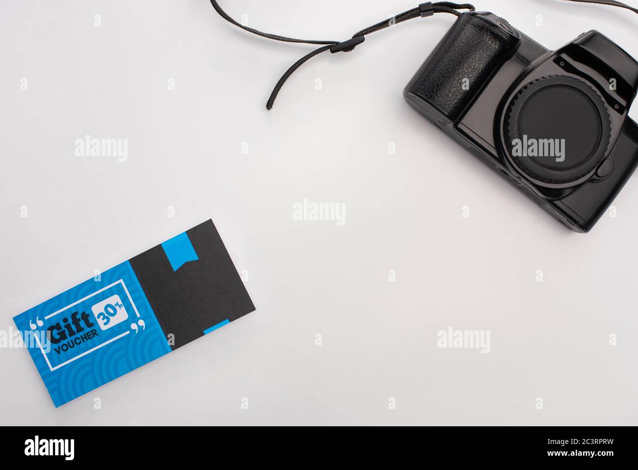 Top view of blue gift voucher and digital camera on white background ...