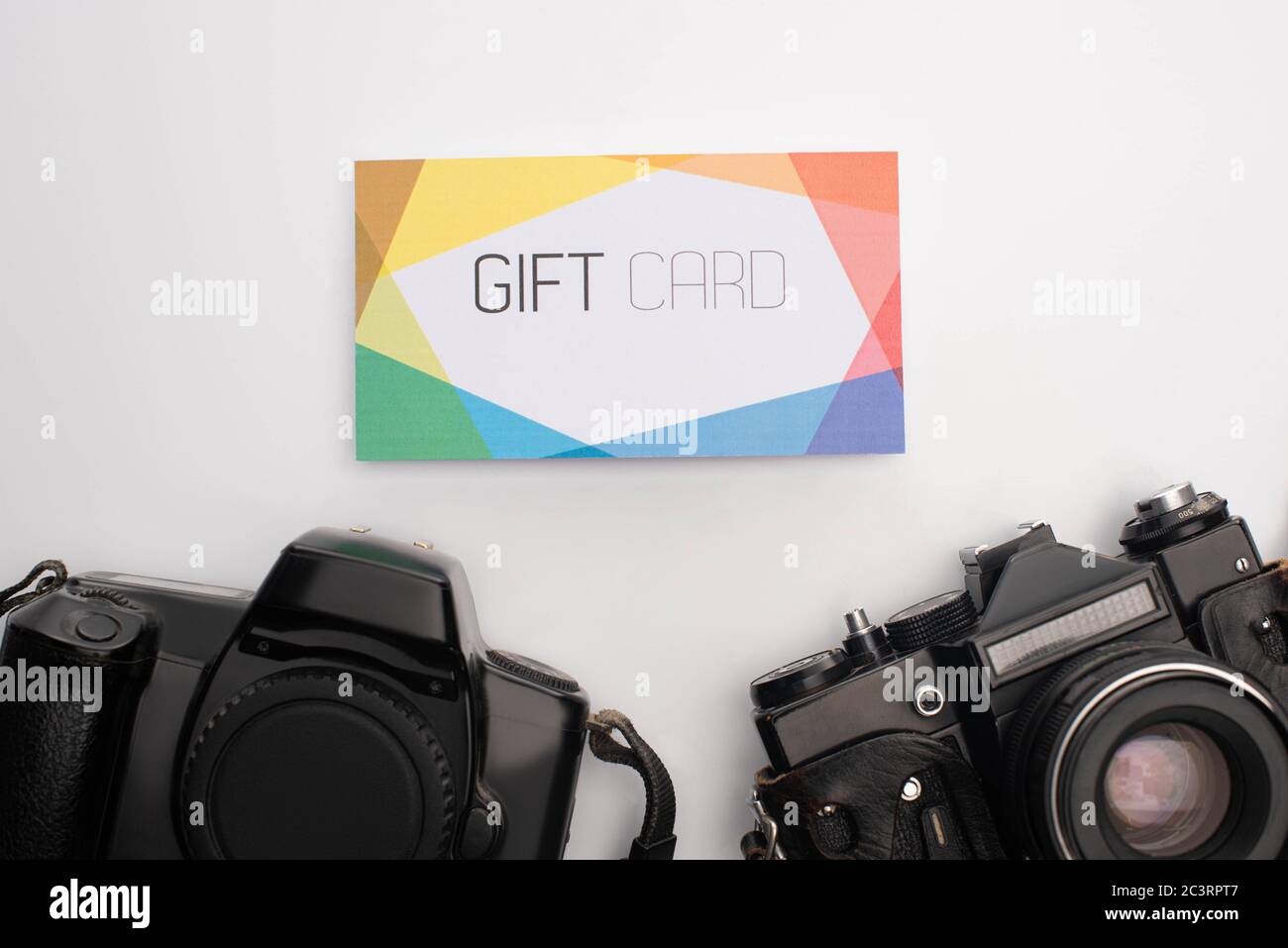 Top view of colorful gift card and digital cameras on white background ...