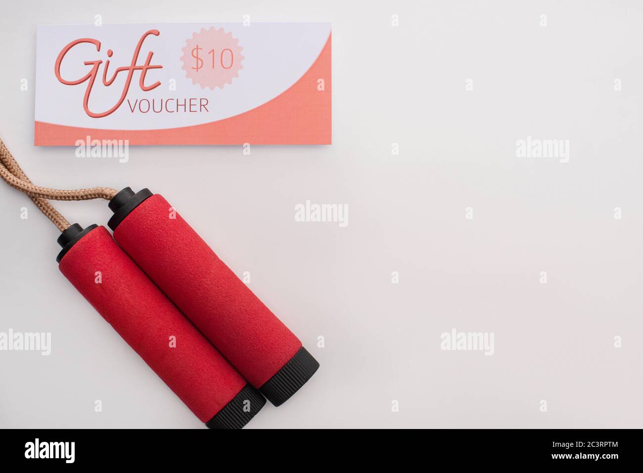 Top view of skipping rope near gift voucher with 10 dollars sign on ...