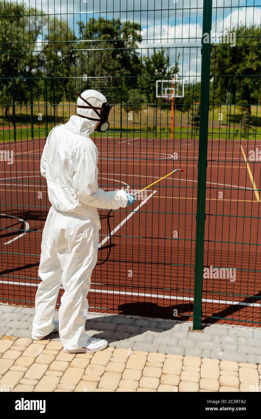 specialist in hazmat suit and respirator disinfecting fence of ...