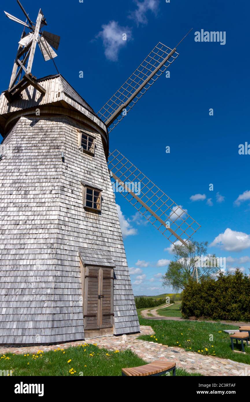 Old windmill in a country landscape with woodland trees under a cloudy ...