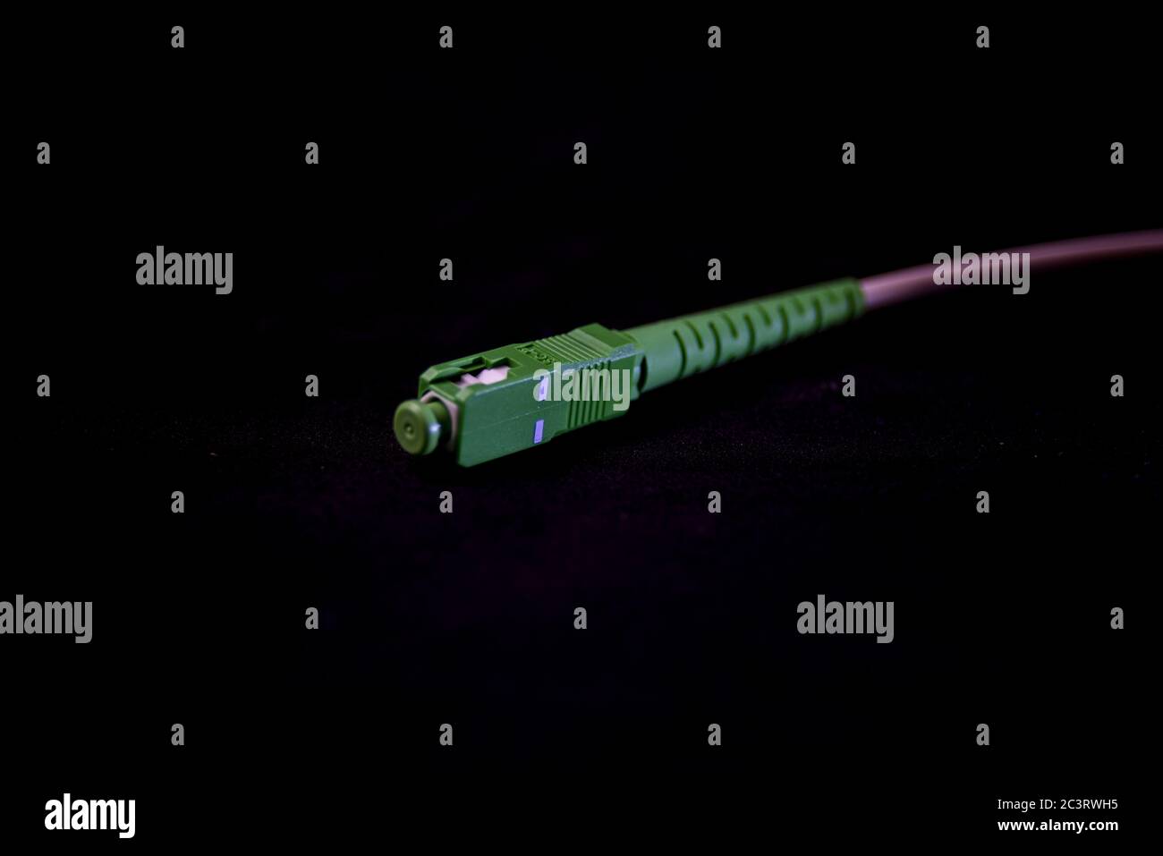 Optical fiber cable with connector isolated on a black background Stock ...