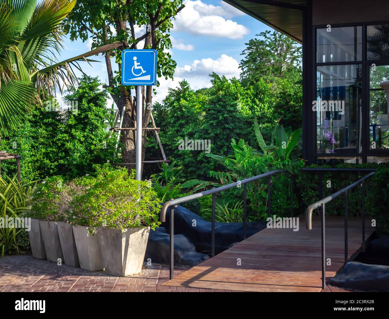 Disabled way sign in front of cafe on green nature landscape background ...