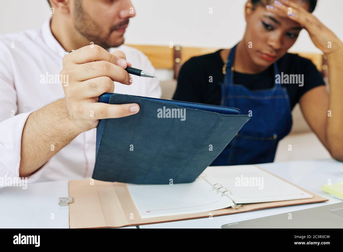Bakery shop owner discussing financial report with poor figures with ...