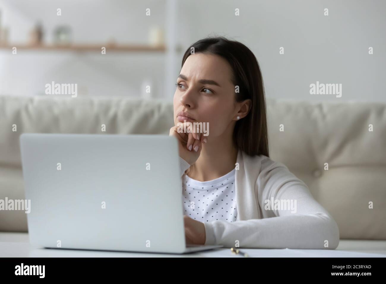 Pensive girl sit in front of laptop thinking over task Stock Photo - Alamy