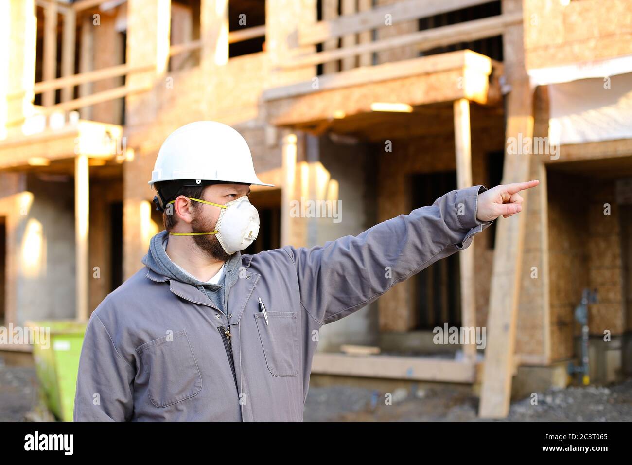 Construction worker wearing respirator and giving indications Stock ...