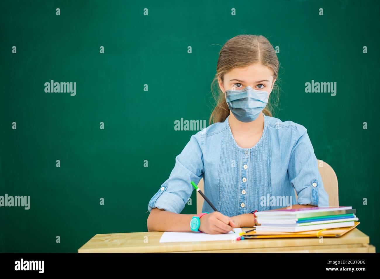 Back to school after quarantine girl sitting in the classroom against ...