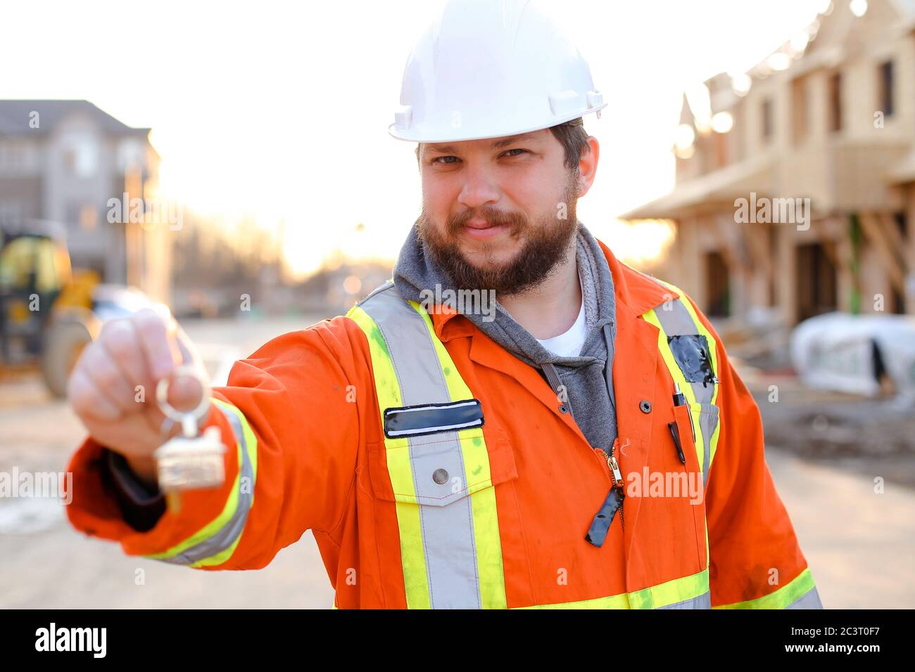 Engineer giving keys from new house on construction site Stock Photo ...