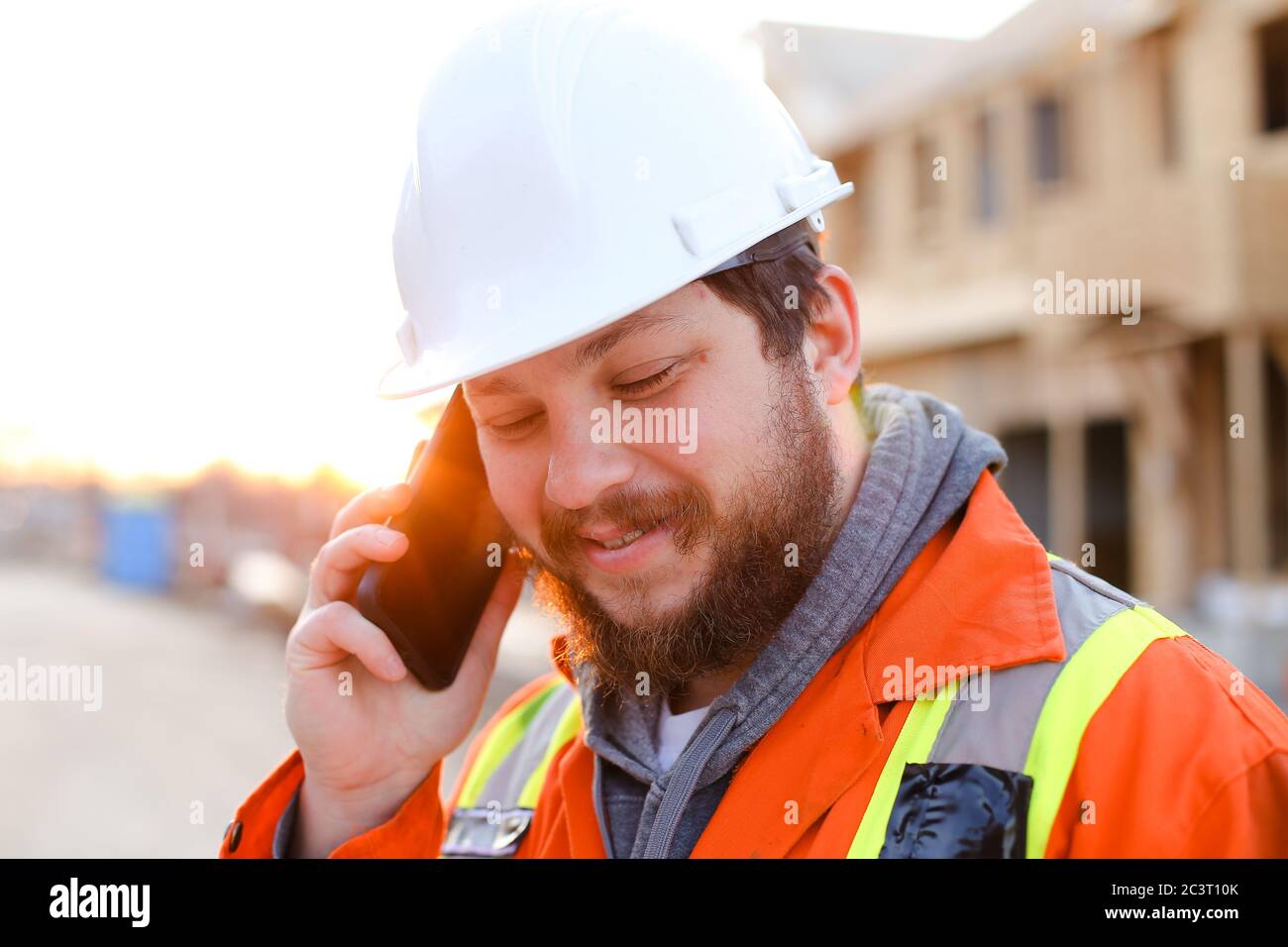 Portrait of builder talking by smartphone on construction site Stock ...
