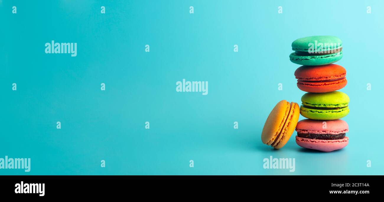 Colored macaroon cookies on a blue banner background. Bright festive ...