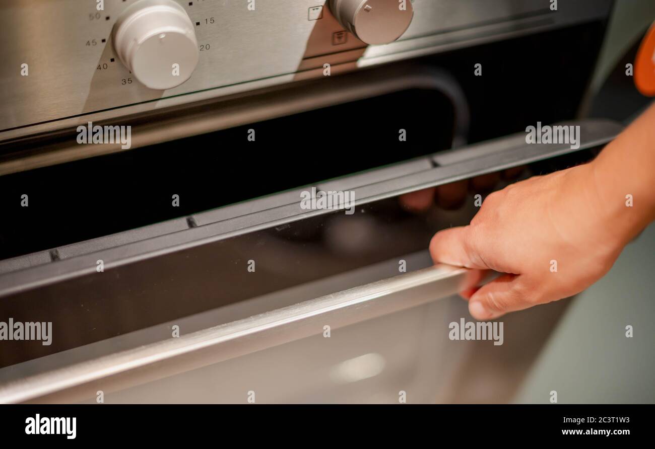 Female hand Opening Or Closing modern electric oven prepare to cooking ...