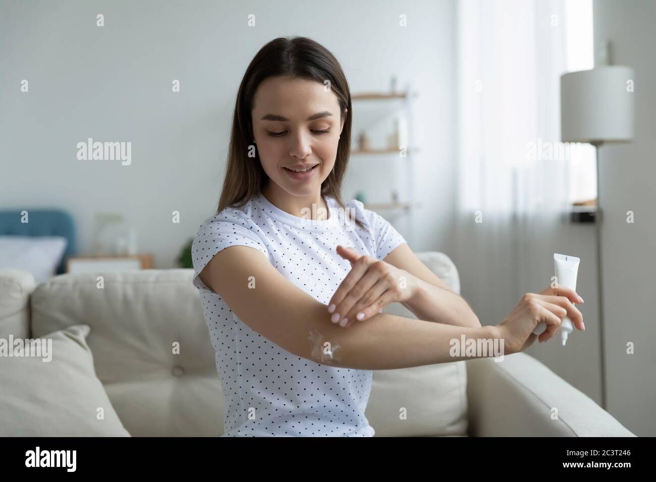 Woman creme holding tube apply cream nourish elbow area Stock Photo - Alamy