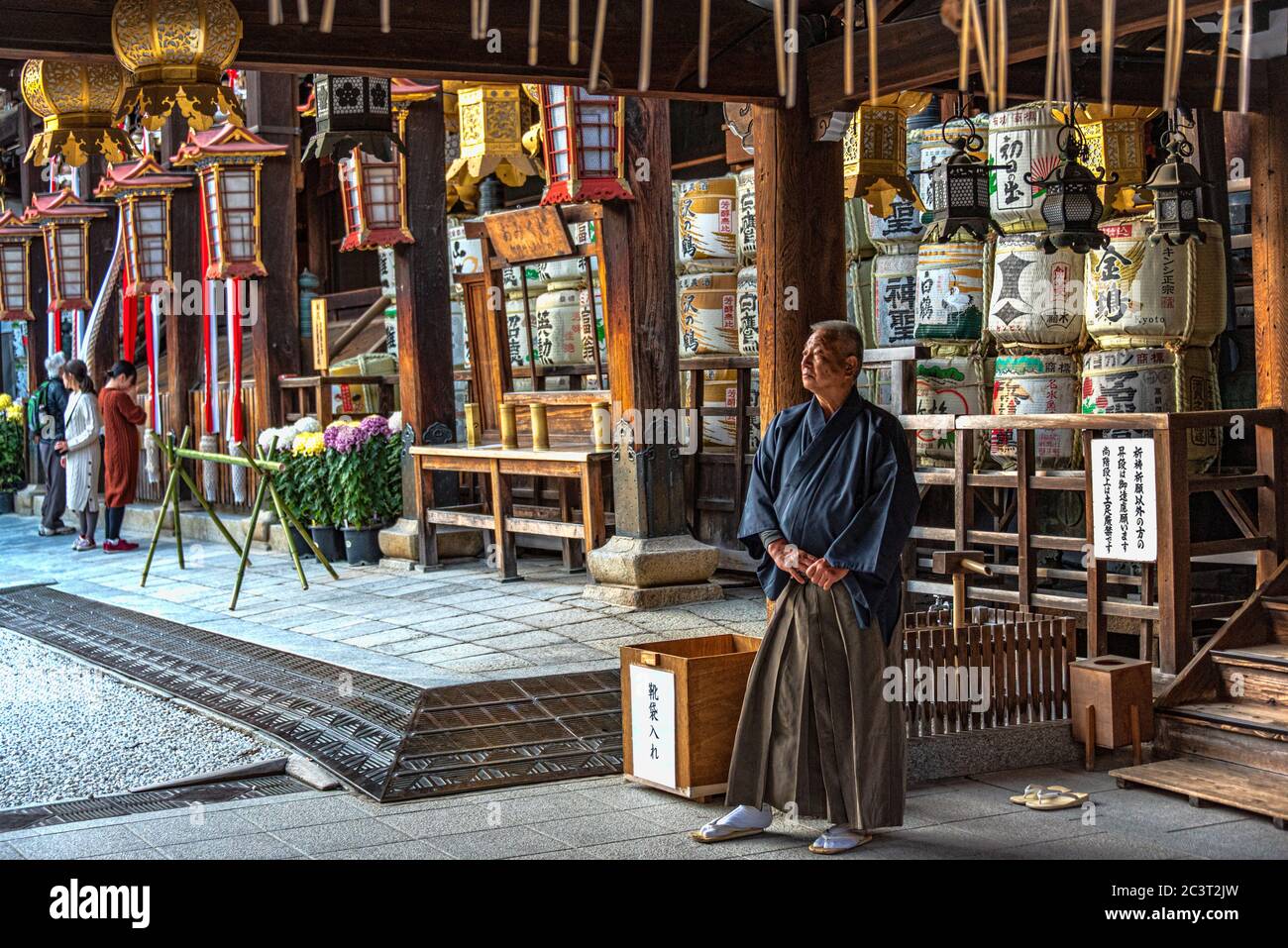 Monk in traditional robes standing in front of altar, Kitano Tenmangu ...