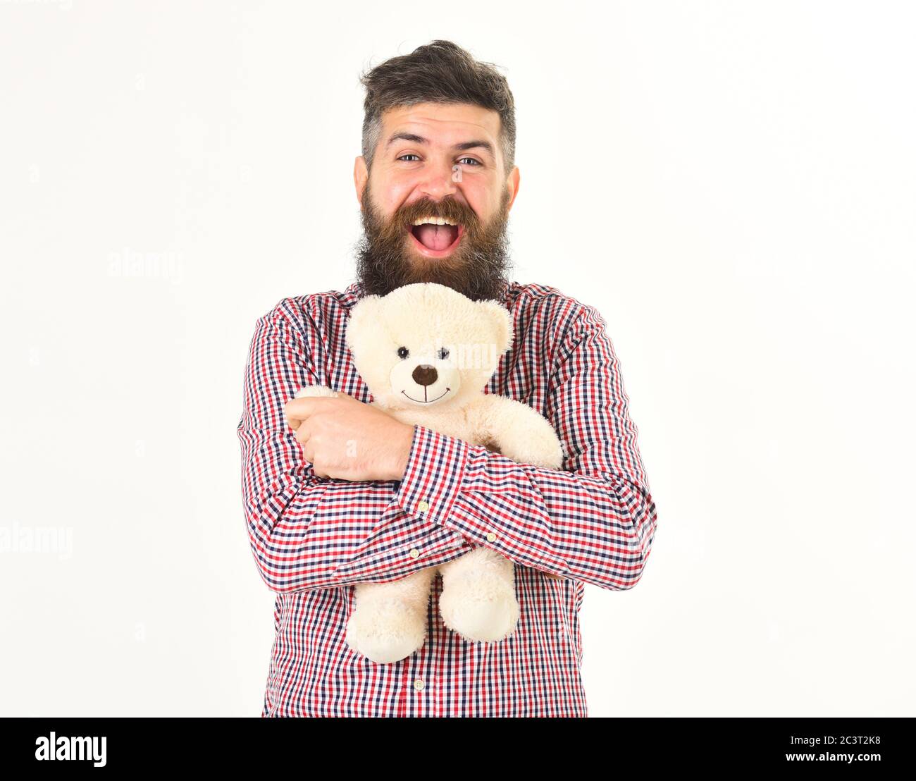 Guy with beard hugs soft toy with tenderness. Hipster cares about teddy ...