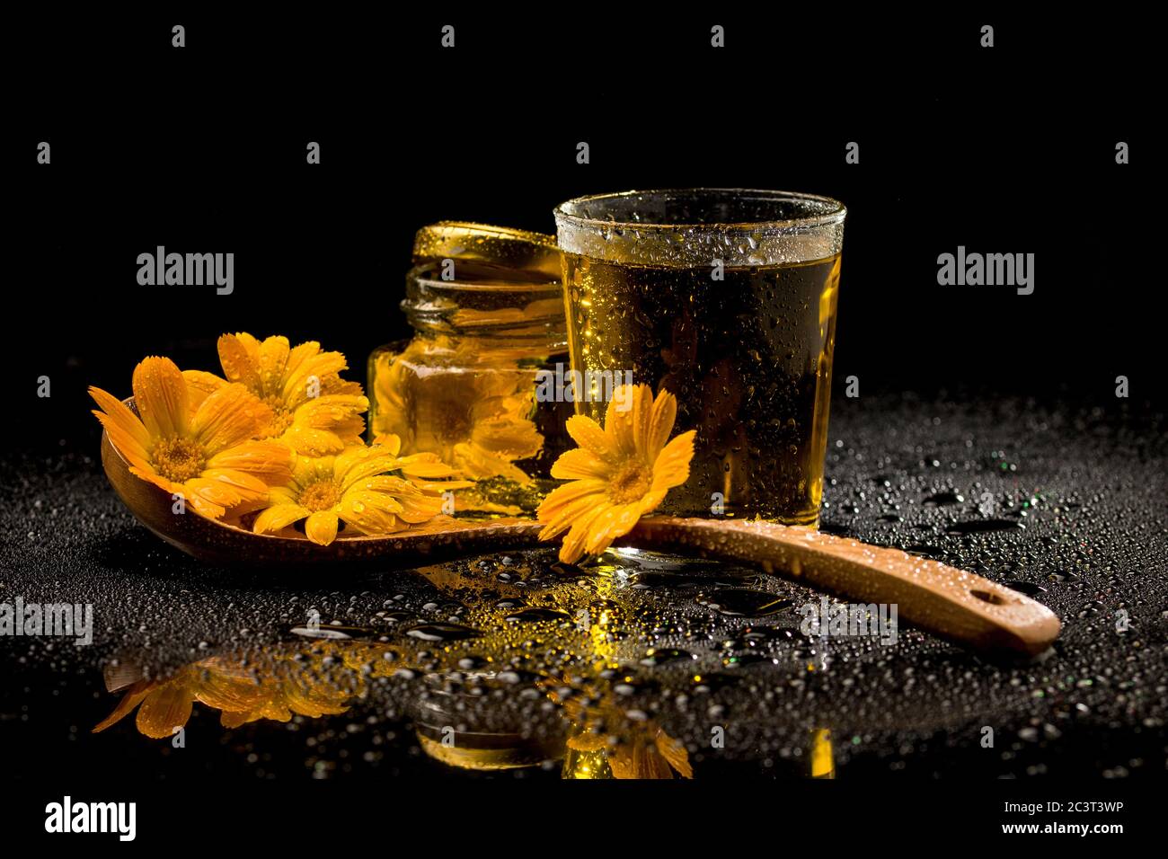 Dried calendula tea in a spoon on black background Stock Photo - Alamy