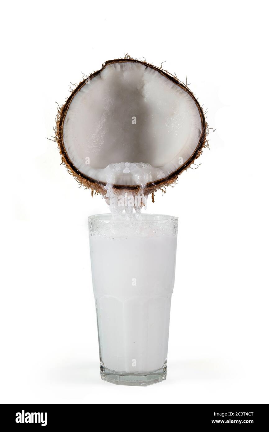 Coconut with flowing juice in a glass. Isolated on white background ...