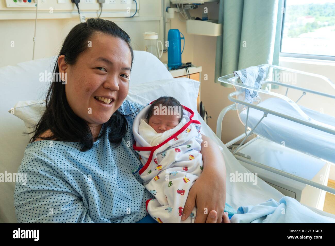 Happy Asia Chinese Mother holding her newborn child after labor in ...