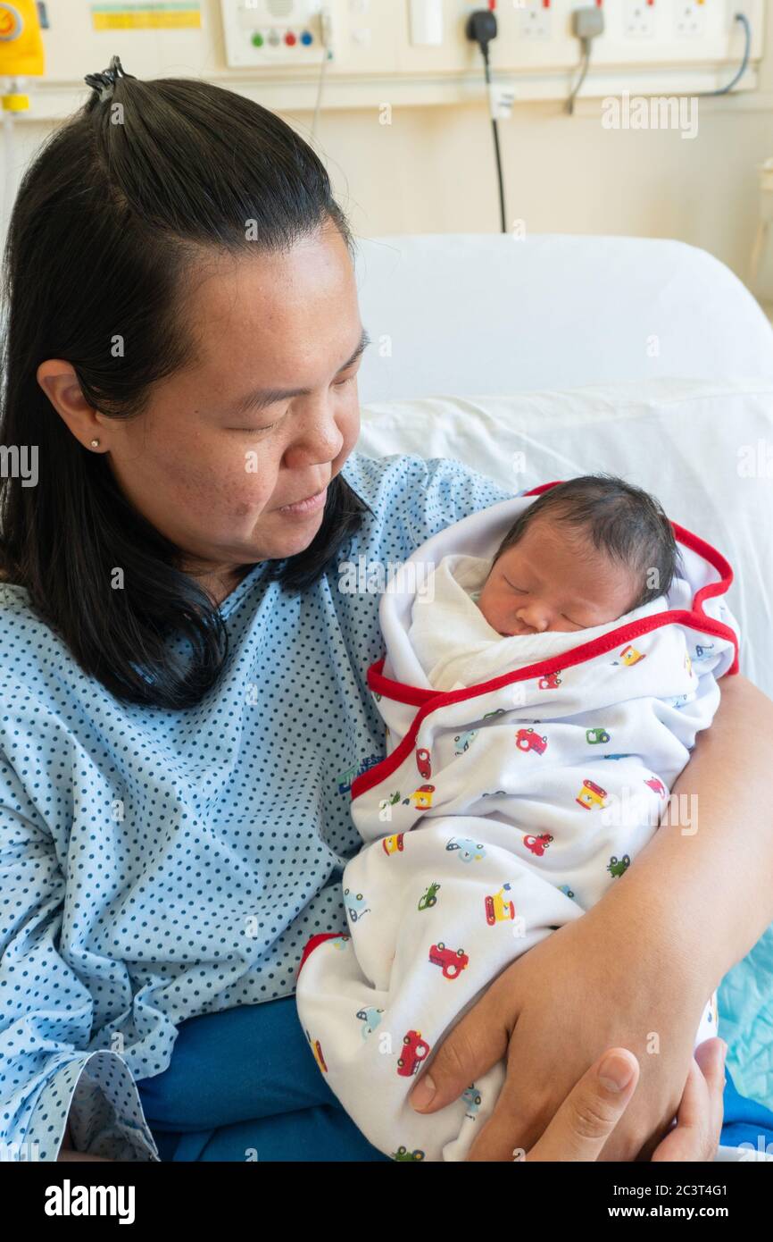 Happy Asia Chinese Mother holding her newborn child after labor in ...
