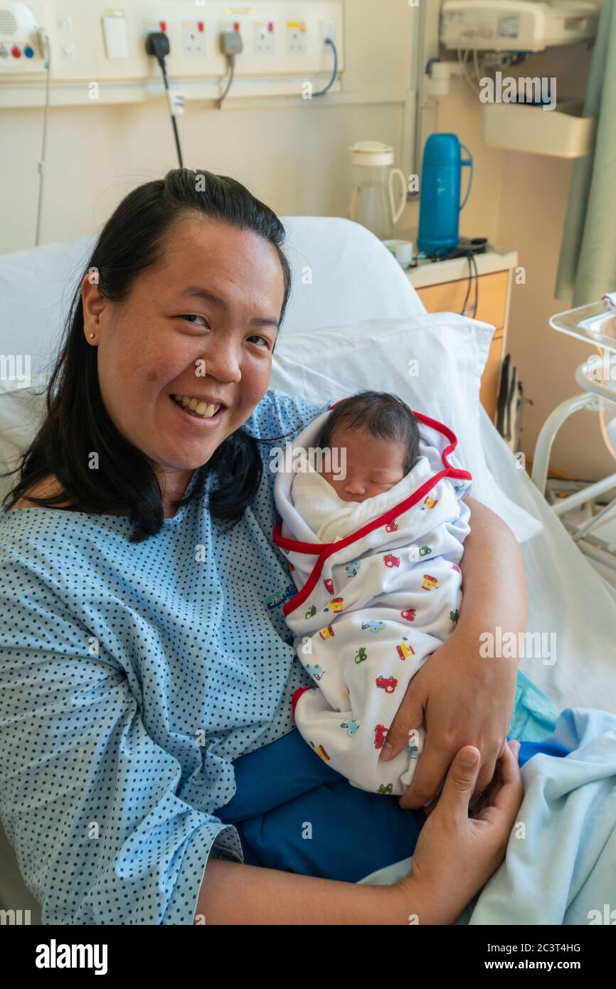 Happy Asia Chinese Mother holding her newborn child after labor in ...